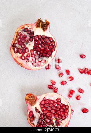 Pomegranate split open with pips on a grunge surface with copy space ...