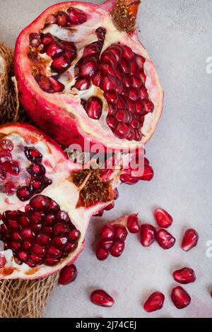 Pomegranate split open with pips on a grunge surface with copy space ...