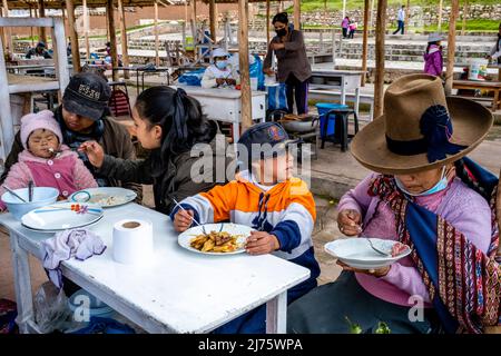A Peruvian Family Eating A Meal At The Sunday Market In The Village Of ...