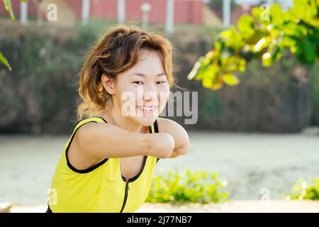 happy asian armless woman warming up before swimming at the tropical ...