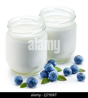 Two glass containers with plain yoghurt and berries on the table. Light ...