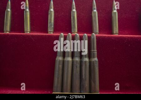 many war gun bullets close up detail on red background Stock Photo - Alamy