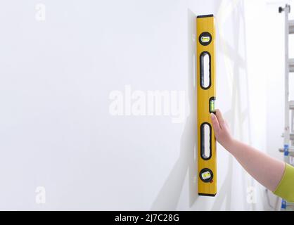 Architect measuring wall with level tool at site Stock Photo - Alamy