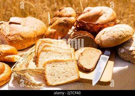 lot of different flavored bread, wheat, rye, on the table in the field outside Stock Photo - Alamy