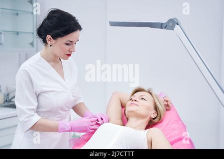 Woman receiving underarm injection in cosmetology clinic Stock Photo ...