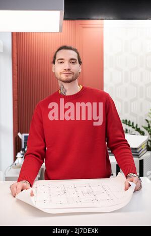 Architect with blueprints and layout design project at office bureau ...