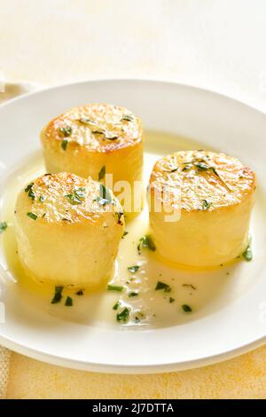 Fondant potatoes on plate over light background. Close up view Stock ...