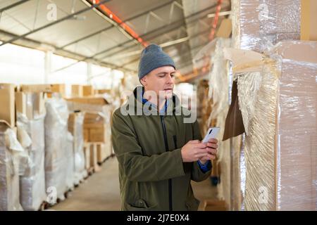 Storekeeper using his phone to take photograph of pasteboard box Stock ...