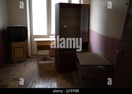 A bedroom of an abandoned house with dirty walls and broken furniture ...