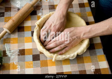 Sooking and home concept - close up of male hands kneading dough on a ...