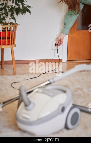 A power supply cable, to a vacuum cleaner, on a kitchen floor in a ...