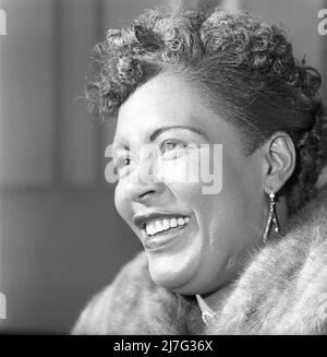 American jazz singer Billie Holiday singing into a microphone at a ...