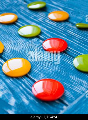 A set of colorful glass buttons for clothes on a dark wooden background ...