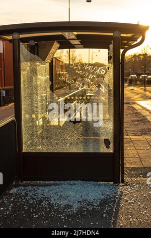 A damaged with broken glasses bus stop. The aftermath of the anti ...