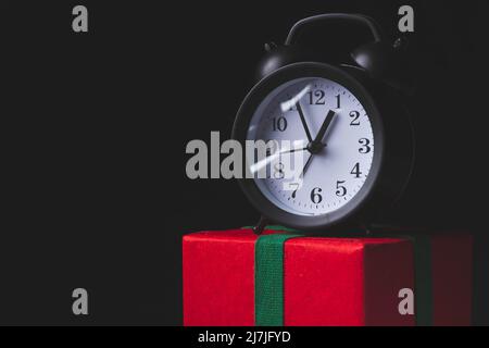 Waiting for the new year. Clock with an alarm clock and a gift. Happy ...