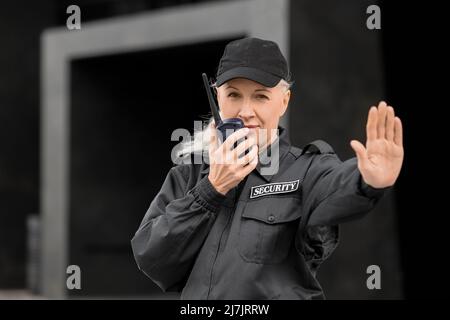 Female security guard showing stop gesture outdoors Stock Photo - Alamy