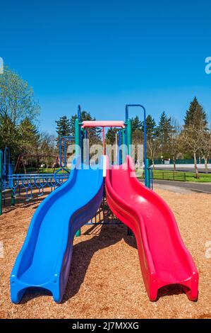 Red and blue plastic slides at Lincoln Park playground in Portland ...