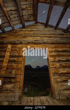 A log cabin and the beautiful mountains of the Wind River Range Stock ...