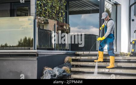 Caucasian Homeowner Using Powerful Pressure Washer to Clean Dirty ...