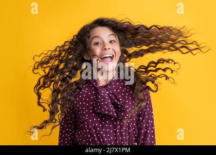 amazed child with long hair on yellow background, portrait Stock Photo ...