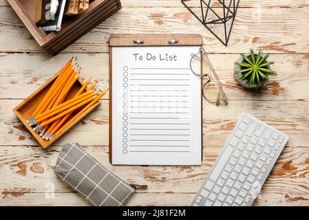 Clipboard with blank to do list, eyeglasses and pencils on light wooden ...