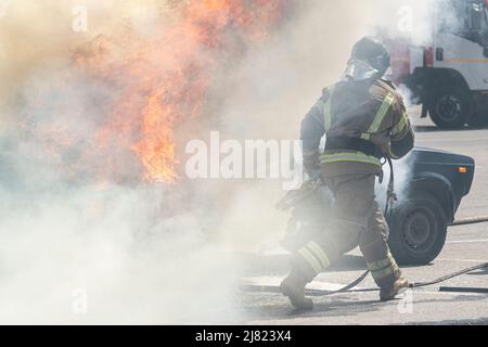 fireman putting out car fire wearing breathing apparatus. devon and ...