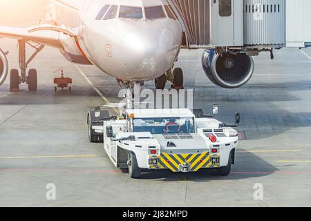 Towing truck pushing back ready to tow the plane jet to the parking ...