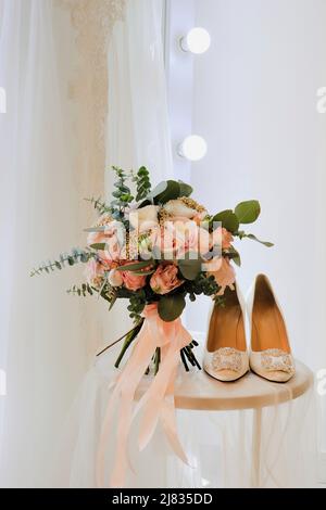 White silk wedding shoes. Heels for bride near wicker suitcase and ...