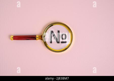 Sign No. under magnifying glass, on pink background Stock Photo - Alamy