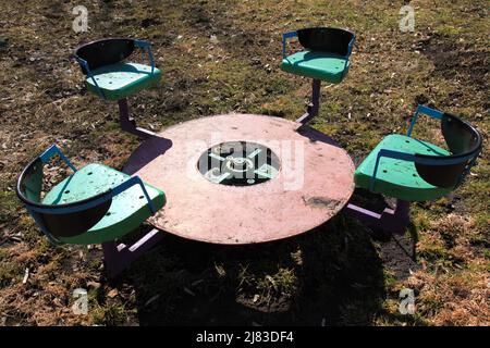 Old rusty disc children's carousel. Desert city and playground with ...