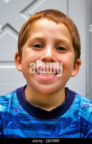 portrait of funny redhead boy with freckles hugs his mom around the ...