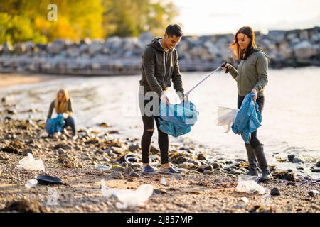 Volunteers cleaning beach on a sunny day Stock Photo - Alamy