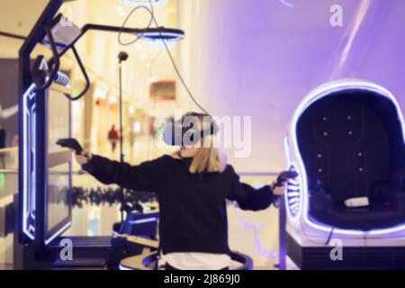 A girl with a joystick in her hands plays a video game online with ...