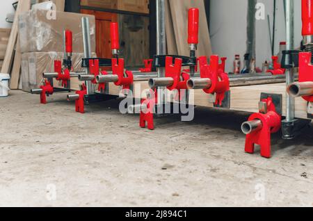 Joiner's clamps on length of bar. Wooden board. Top view Stock Photo ...