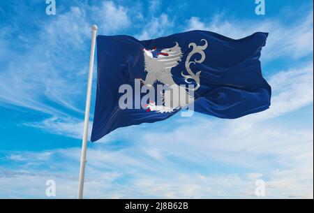 official flag of Hallands , Sweden at cloudy sky background on sunset ...