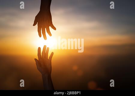 Silhouette of reaching, giving a helping hand, hope and support each ...