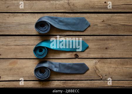 Three blue ties lie on a wooden table, different men's ties close-up ...