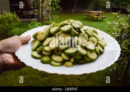 Female holding plate of Spiny gourd vegetable also known as Spine ...