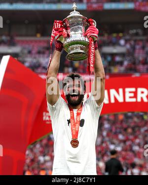 Liverpool goalkeeper Alisson poses with the trophy after the Emirates ...