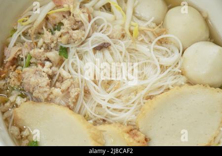 vermicelli rice noodles topping chop boiled pork and fish ball in soup ...