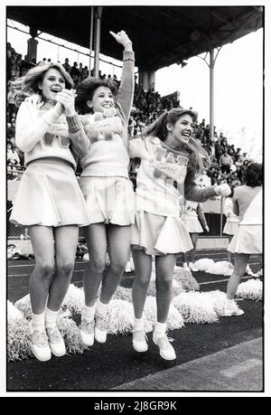 High school cheerleaders have their pompoms in front of them while ...