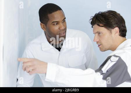two painters talking about the wall Stock Photo - Alamy