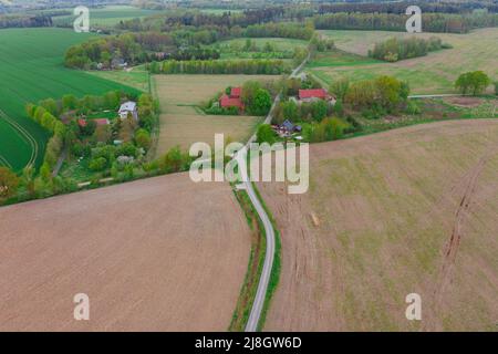 A dirt road running through fields and meadows seen from above. Photo ...