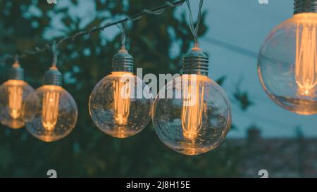 Decorative light bulbs in backyard during the day, selective focus ...