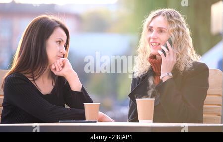 Angry woman being ignored by her happy friends who are checking smart ...