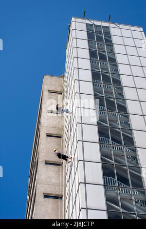Two people abseiling down the tall main tower building of Southend ...