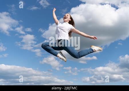 happy teen child jump on sky background. Horizontal poster of isolated ...
