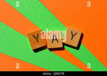 Yay, word in wooden alphabet letters isolated on bright pink background ...