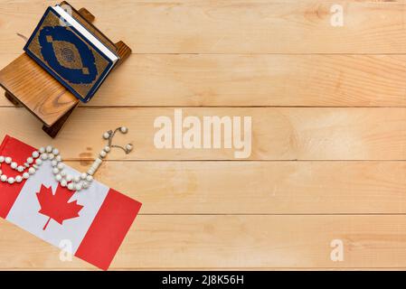 Canadian flag with Muslim prayer beads on blue wooden background Stock ...