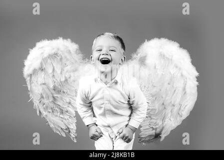 Excited funny angel children boy with white wings laughing. Valentines ...
